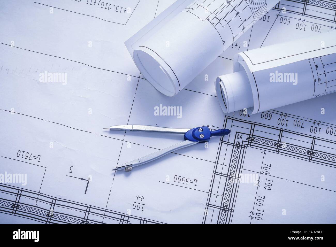 Vertical version compass and rolled blueprints close up Stock Photo - Alamy