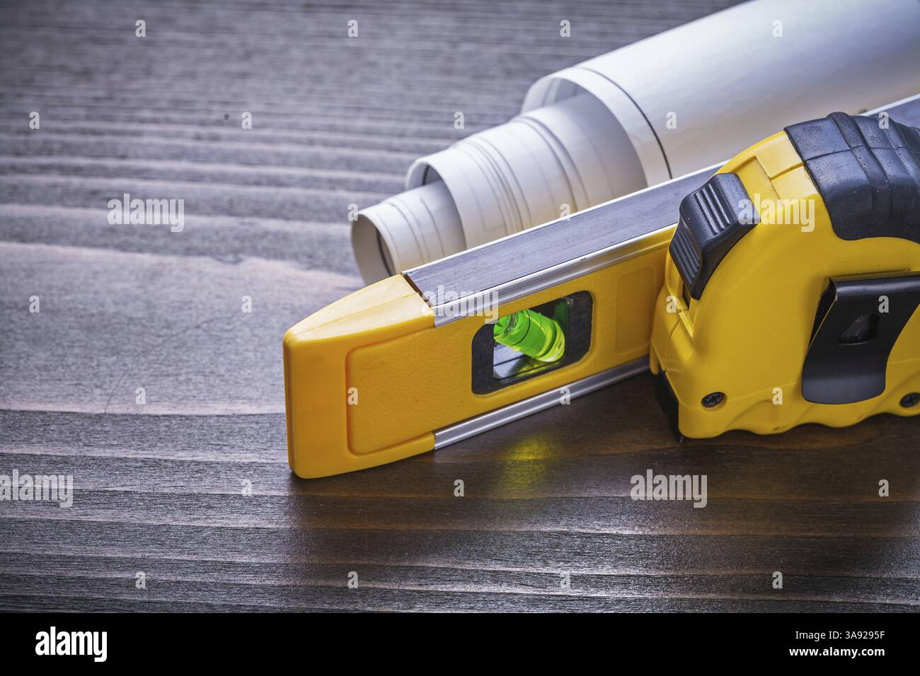 Measuring tape blueprints and construction level on vintage wooden ...
