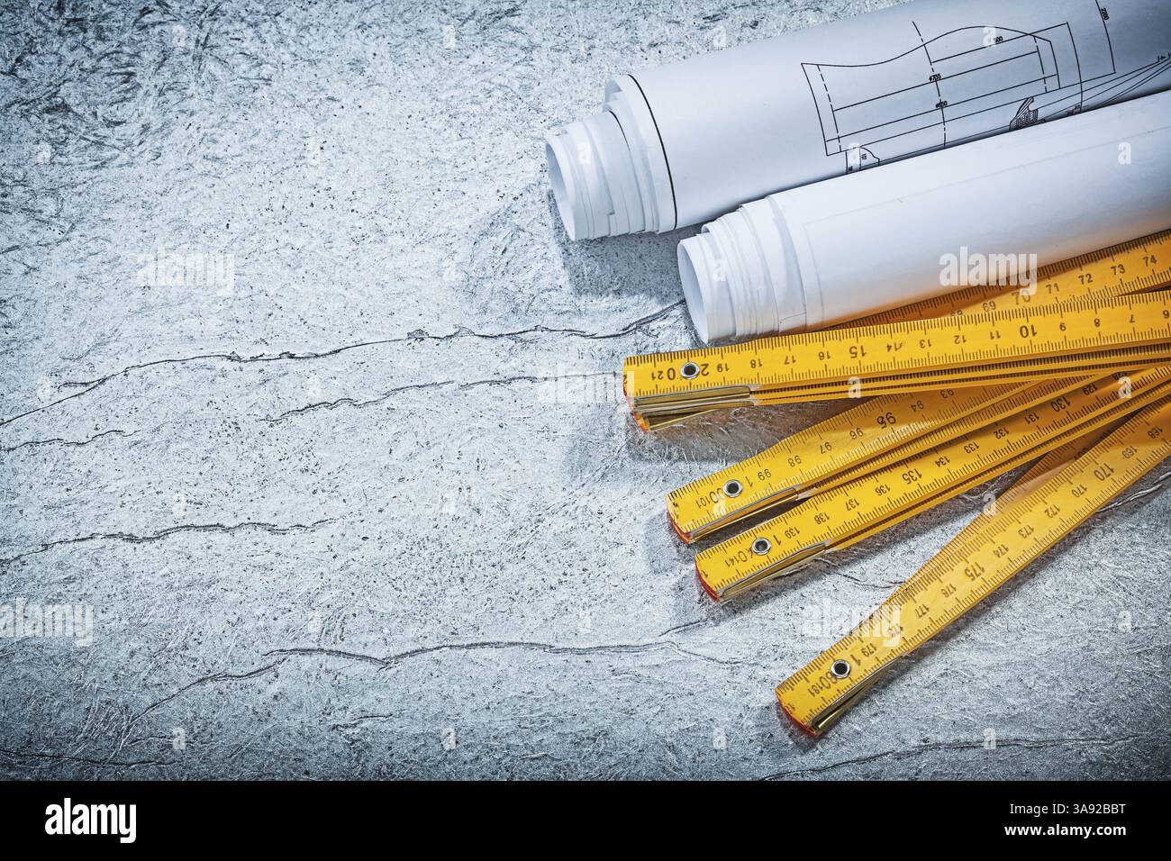 Wooden meter rolled blueprints on metallic background construction ...