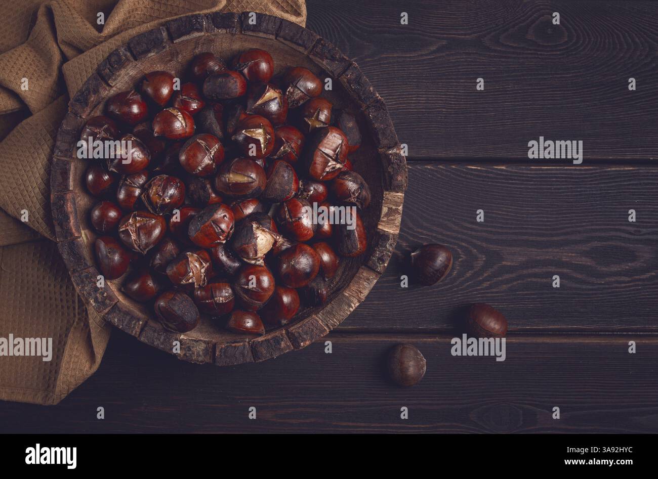 Roasted chestnuts, in a wooden plate, top view, homemade, no people ...