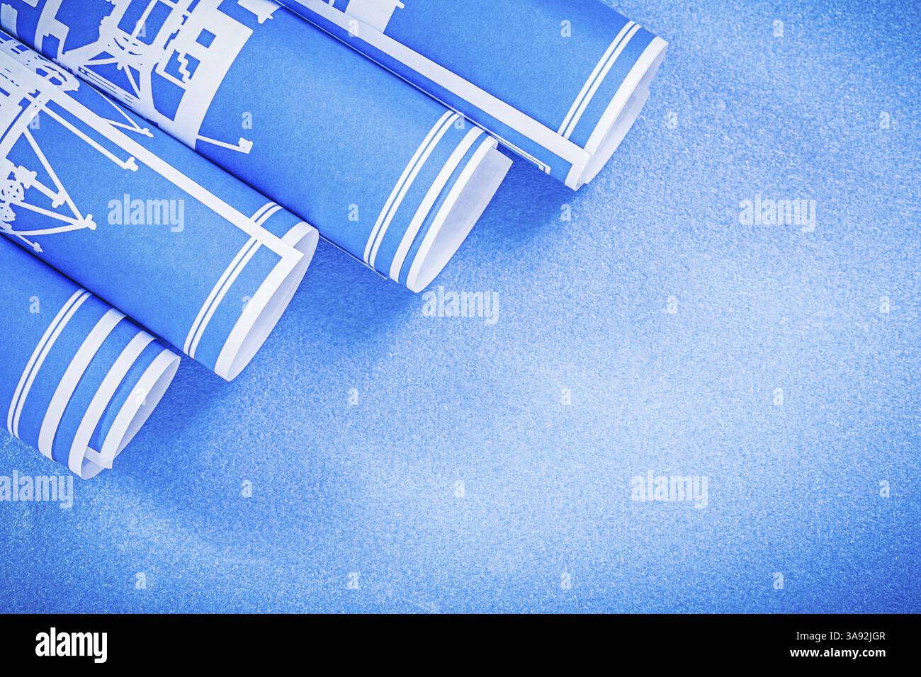 Rolled construction drawings on blue background directly above Stock ...