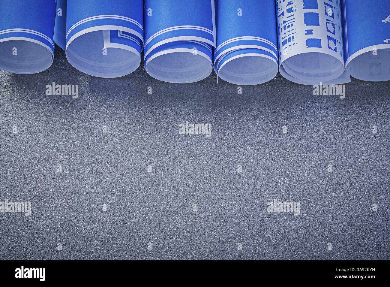 Stack of blue engineering drawings on grey background copy space ...