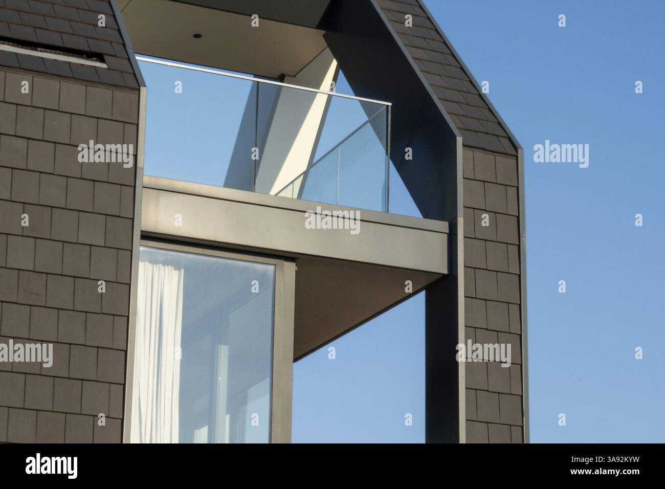 Modern architectural detail featuring a glass balcony, dark tile ...