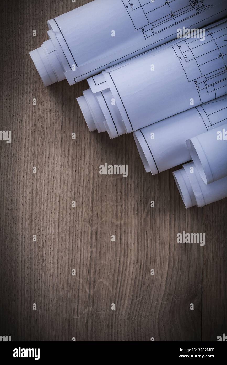 Stack of rolled blueprints on wooden background construction concept ...