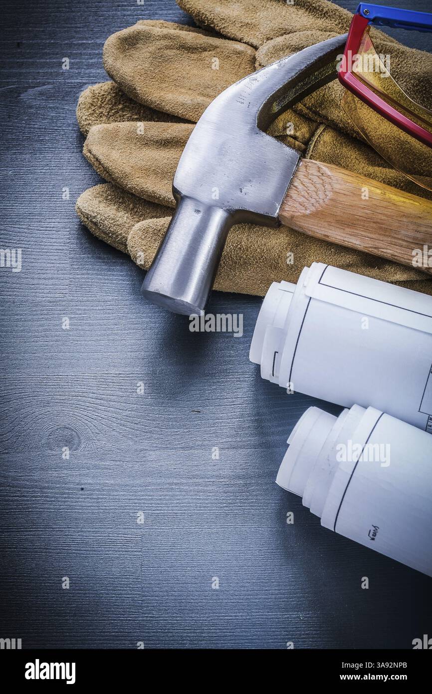 Vertical view rolls of blueprints hammer gloves goggles Stock Photo - Alamy