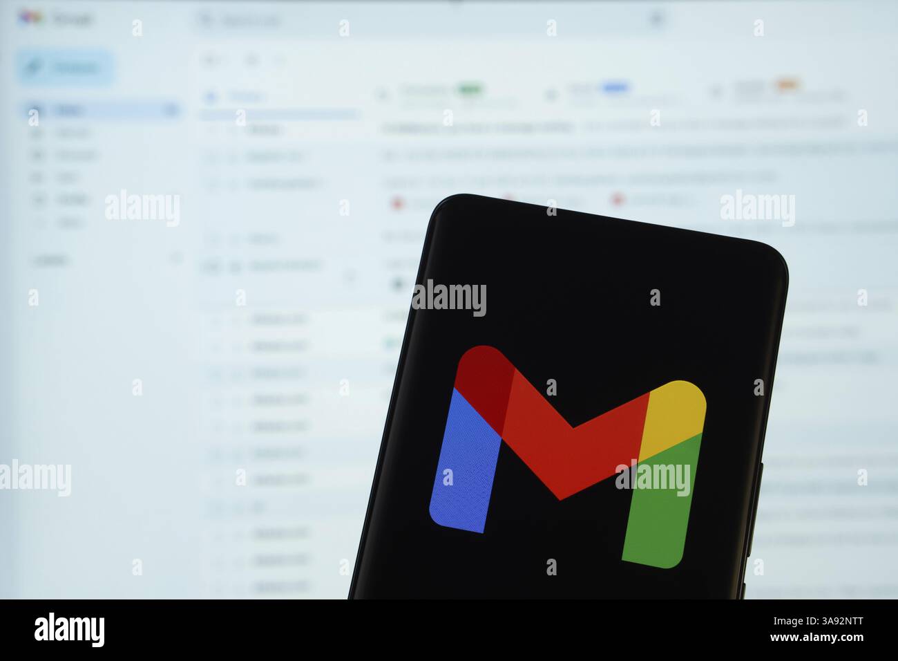 The logo of the Gmail is displayed on a smartphone screen, and the ...