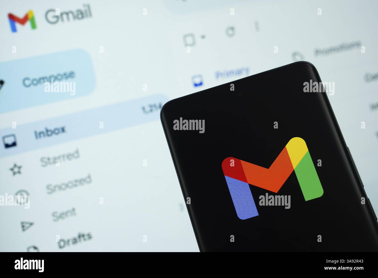 The logo of the Gmail is displayed on a smartphone screen, and the website gmail is visible on a ...