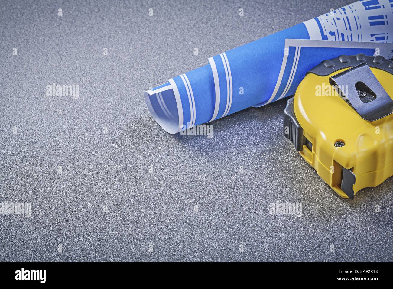Tape-line blue rolled blueprint on grey background construction concept ...