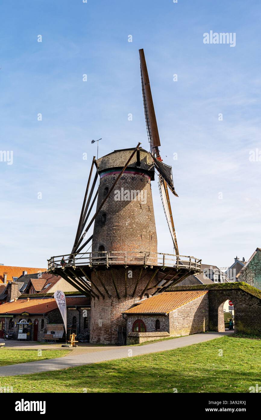 A windmill is standing in Xanten Germany. The windmill is tall and has a large wooden structure ...