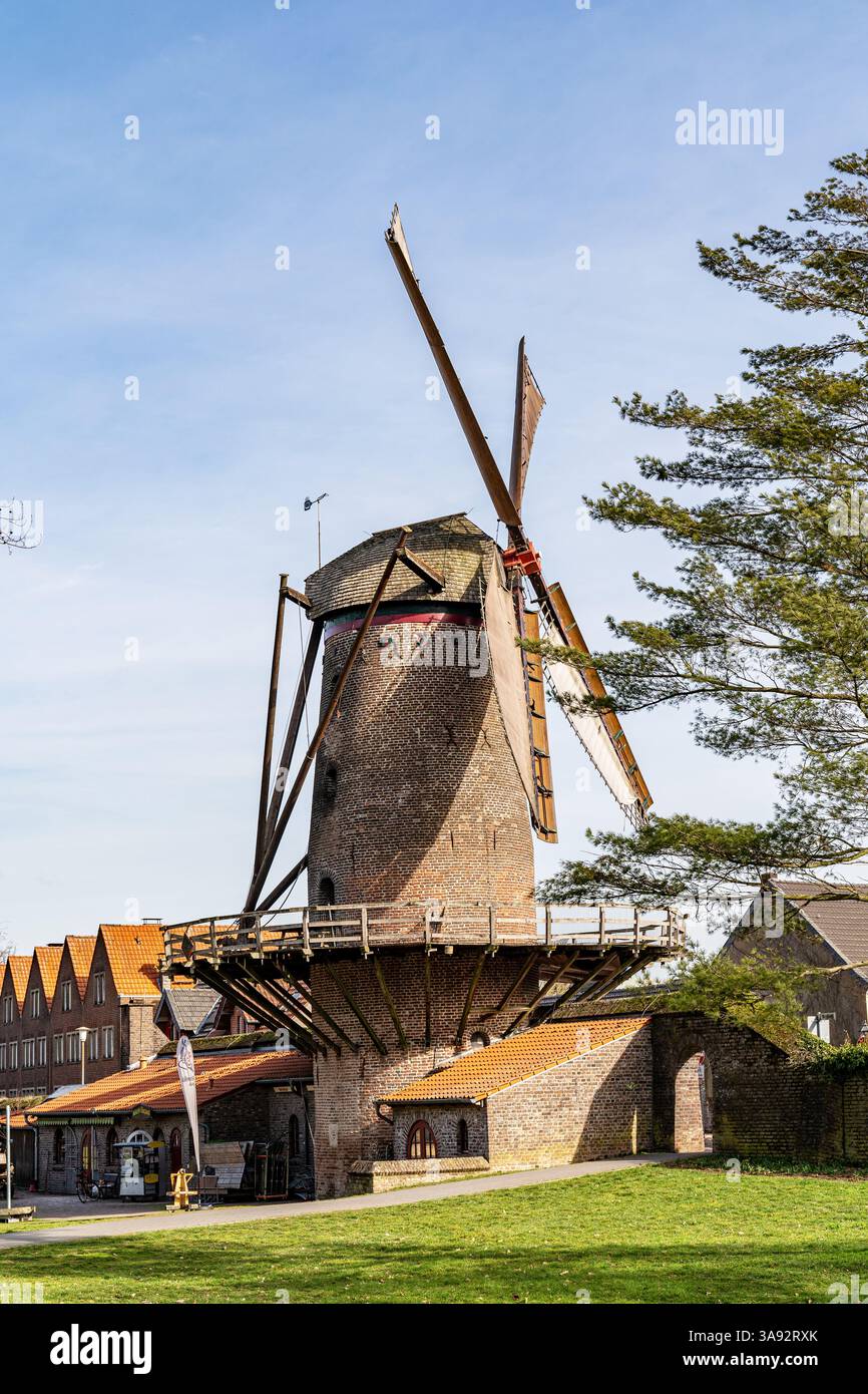 A windmill is standing in Xanten Germany. The windmill is tall and has a large wooden structure ...