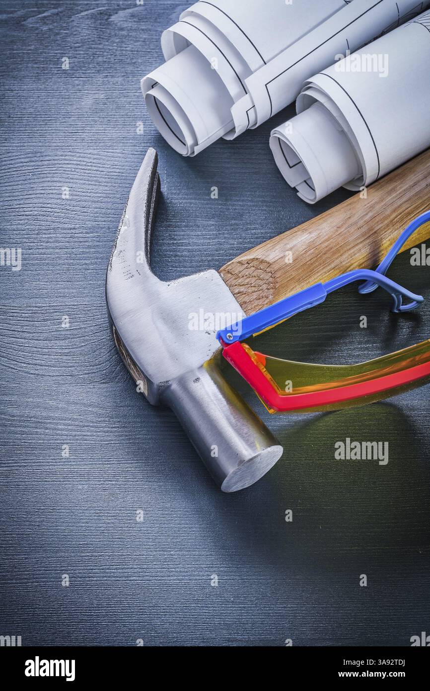 Vertical view rolled up blueprints hammer goggles Stock Photo - Alamy
