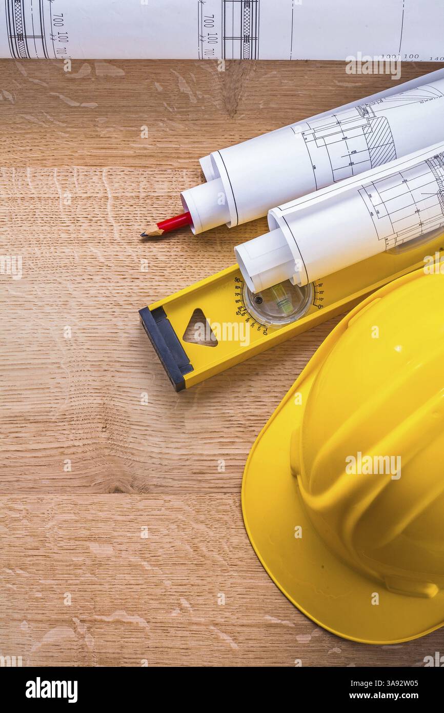View on rolls of white blueprints and level helmet pencil wooden boards ...