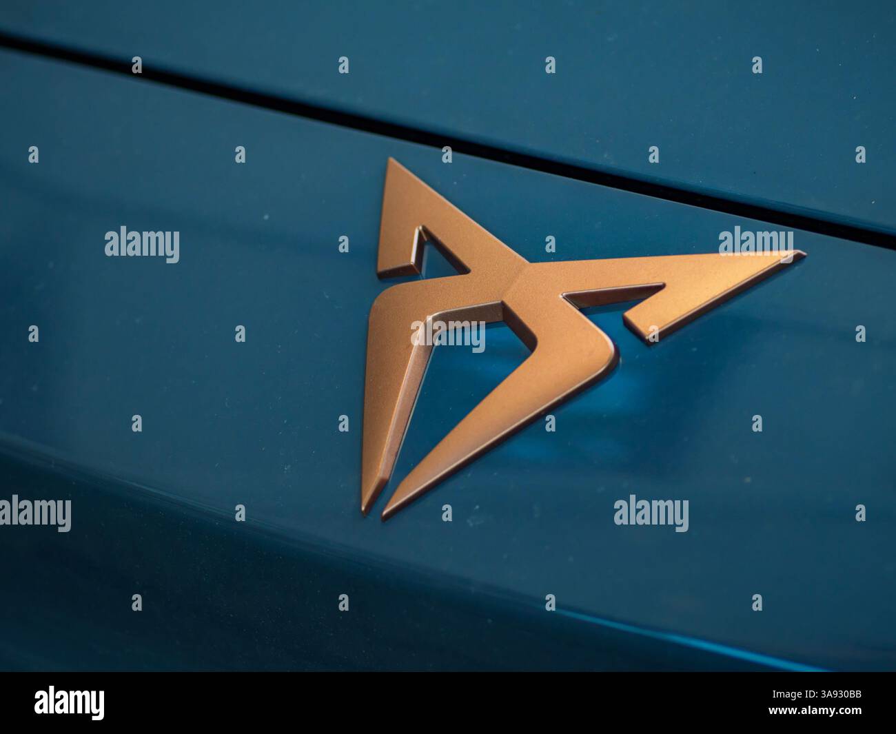 A detailed shot of the Cupra logo, with reflections on the green-blue ...