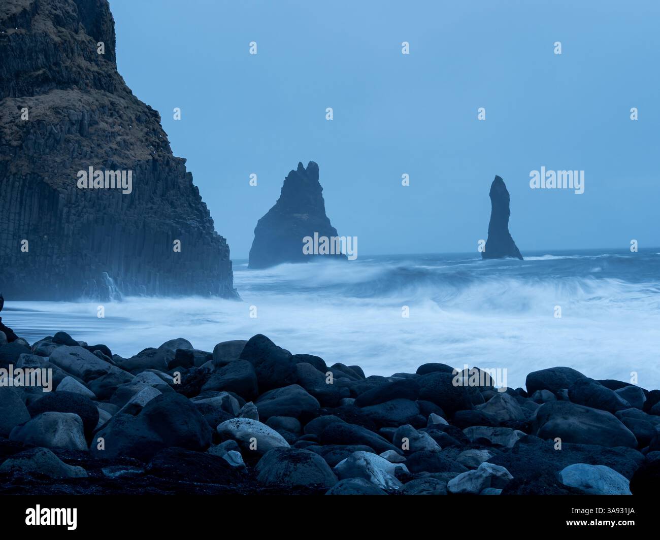 Reynisfjara Beach at dusk, with the iconic Reynisdrangar sea stacks ...