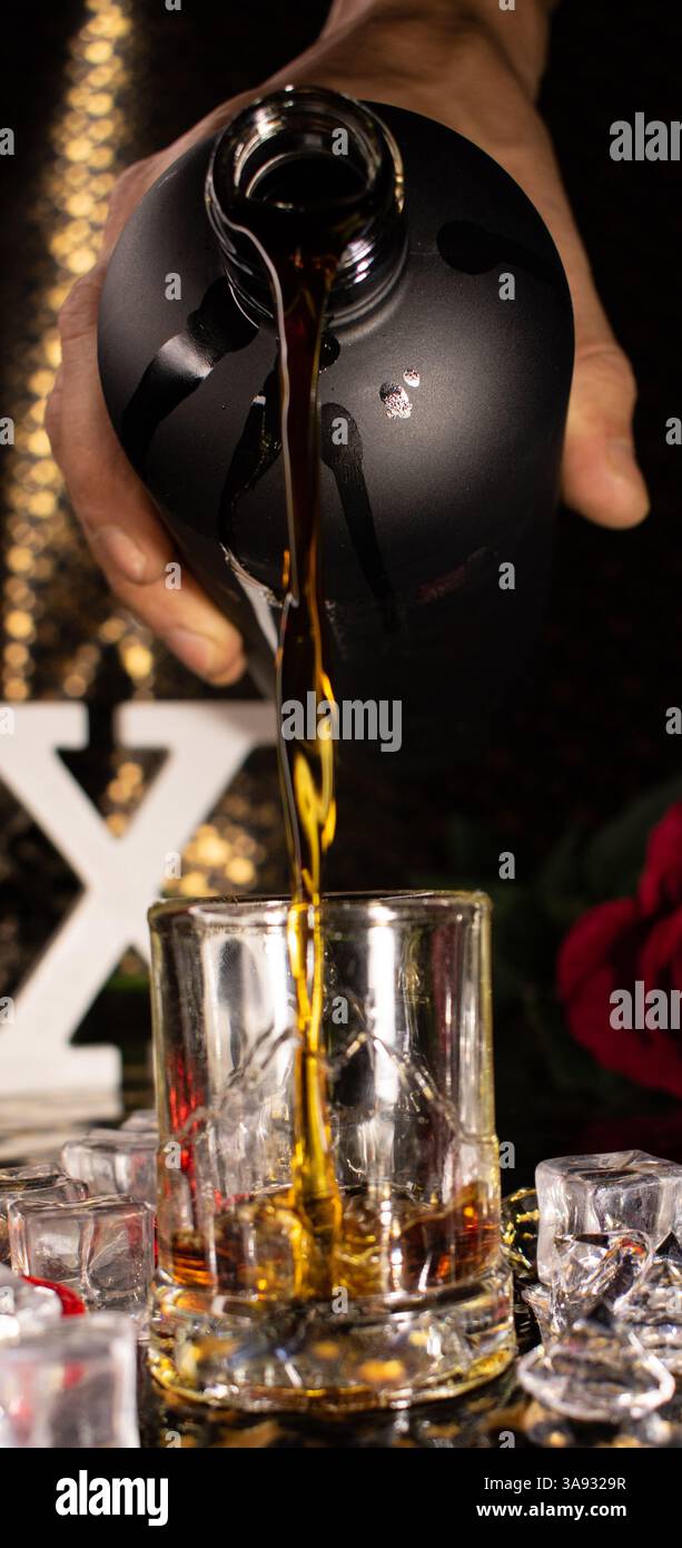 Closeup Barman pouring whiskey into glass Stock Photo - Alamy