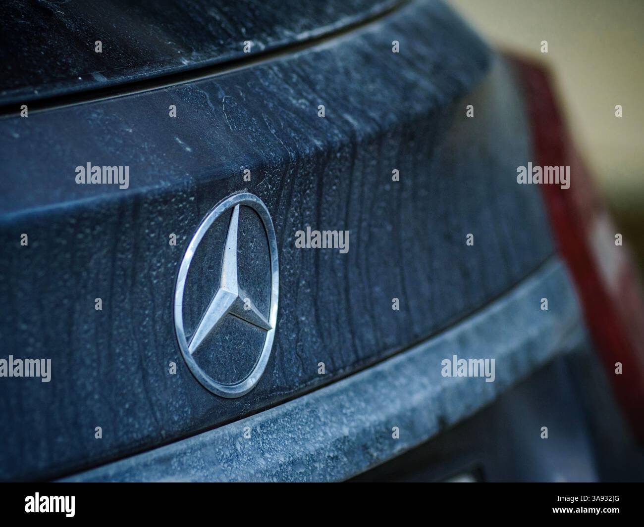 A close-up of a black car's trunk with dust on it, highlighting the ...