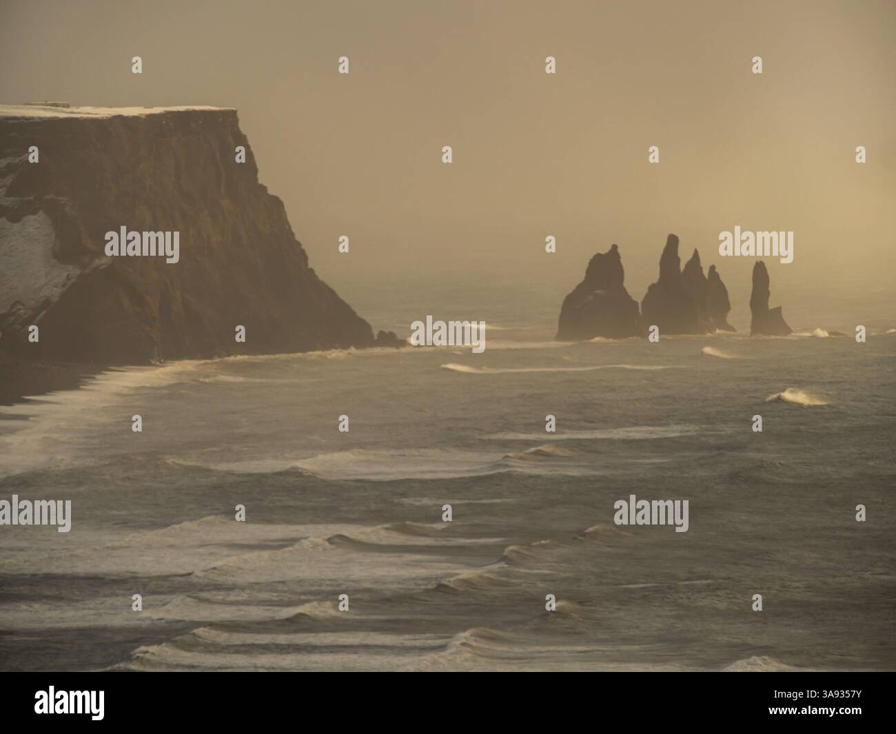 Golden hour view from Dyrhólaey, Iceland, showing the Reynisdrangar sea ...