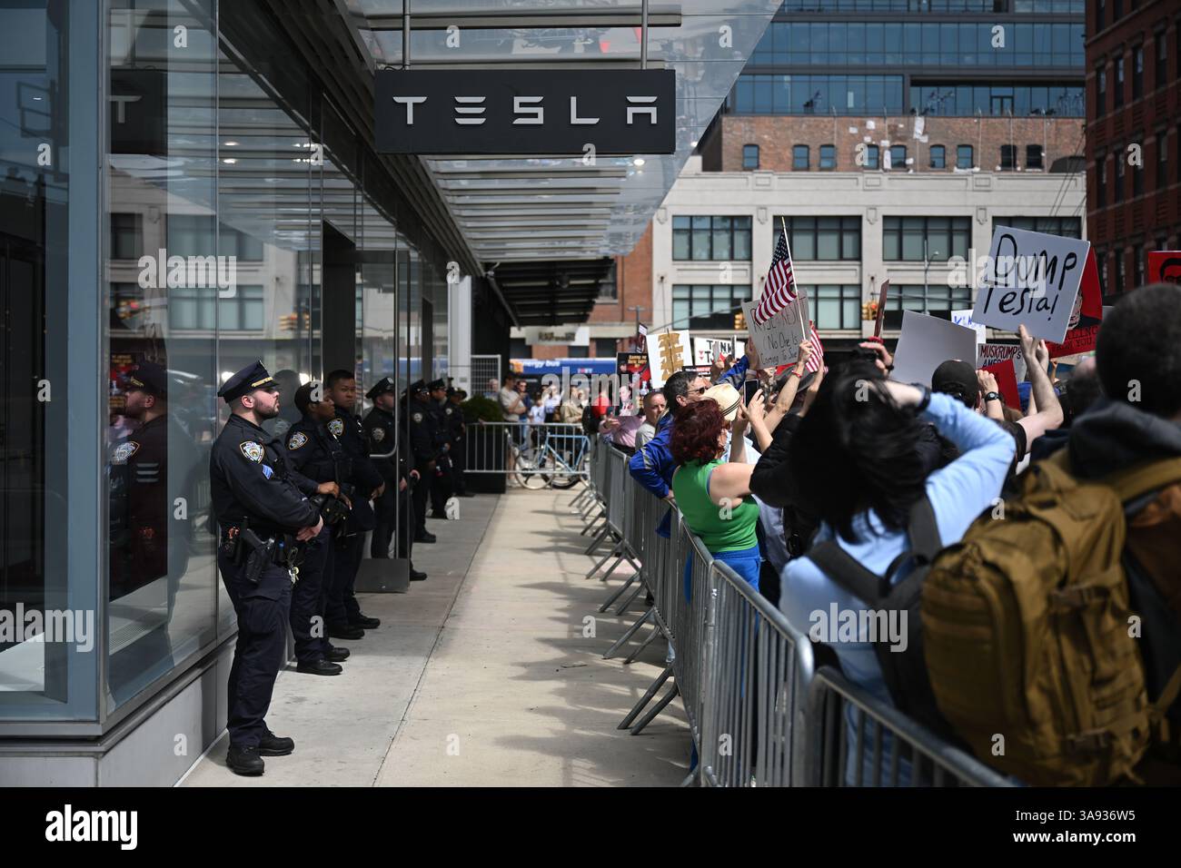 Police officers stand guard outside the Tesla Showroom in the ...