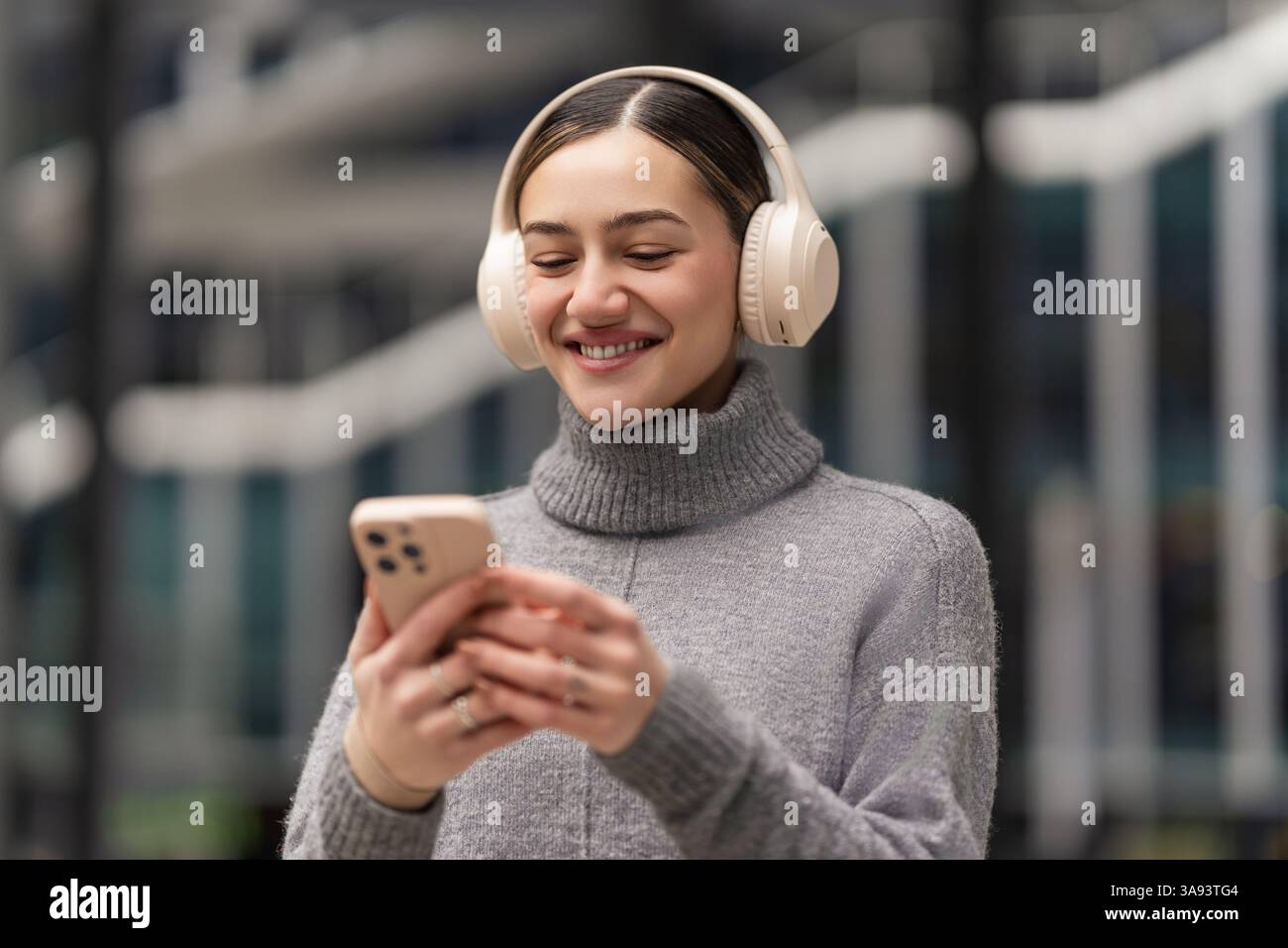 Scrolling, sharing, staying connected. A woman with headphones and ...