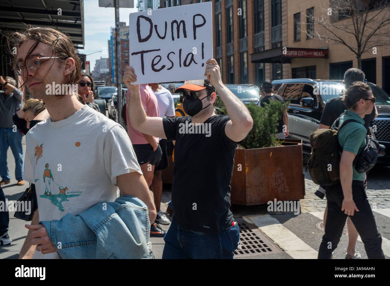 NEW YORK, NEW YORK - MARCH 29: A protester holds a sign during a Tesla ...
