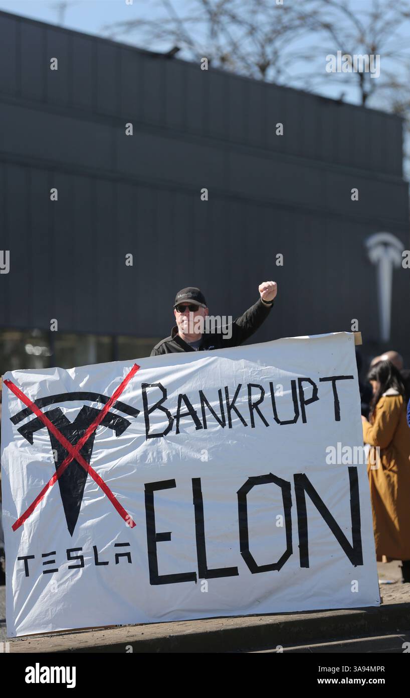 A protester holds a banner saying ‘Bankrupt Elon’ outside the Tesla ...