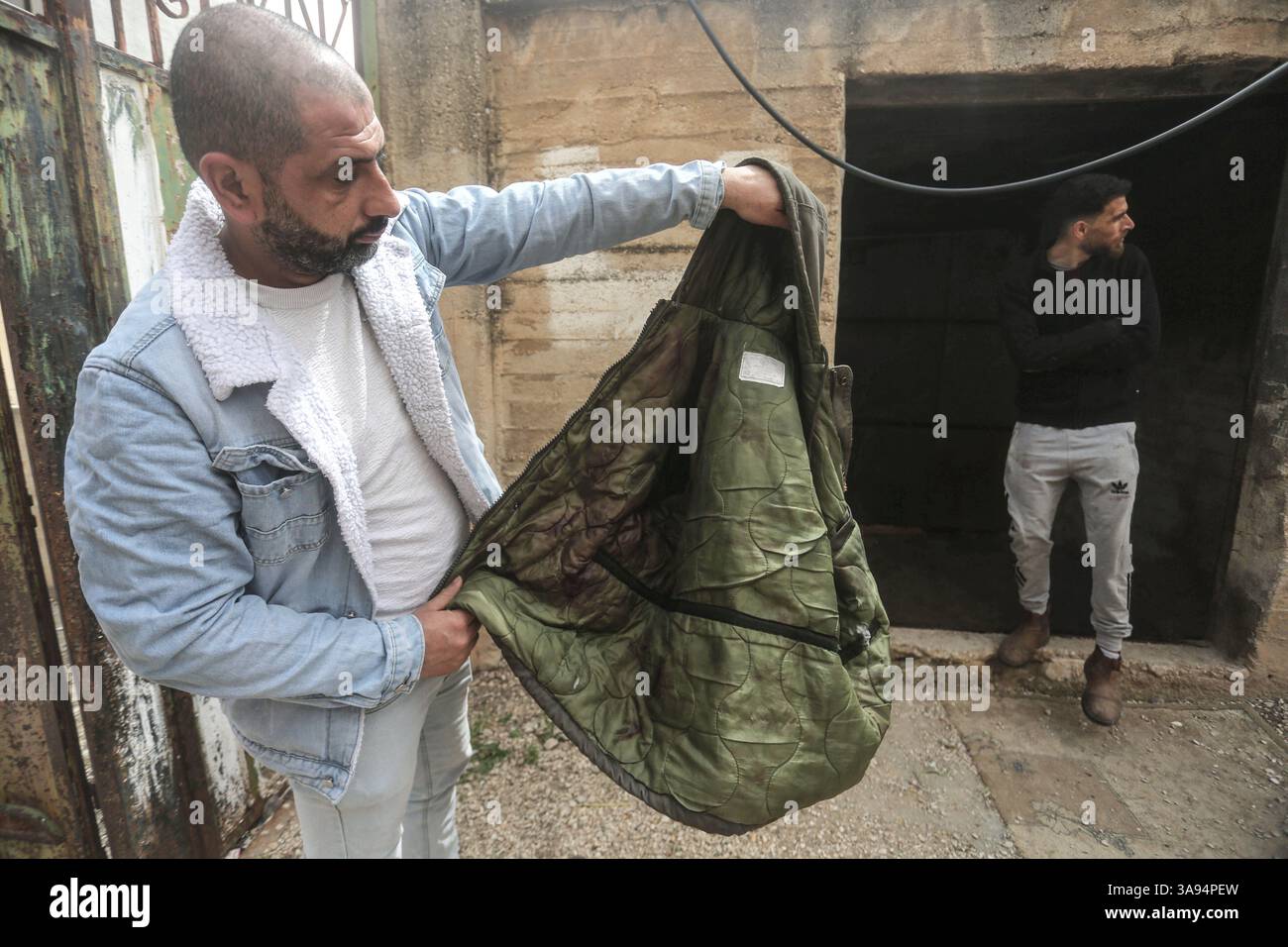 The brother of Palestinian Ahmed Bani Odeh holds his blood-stained ...
