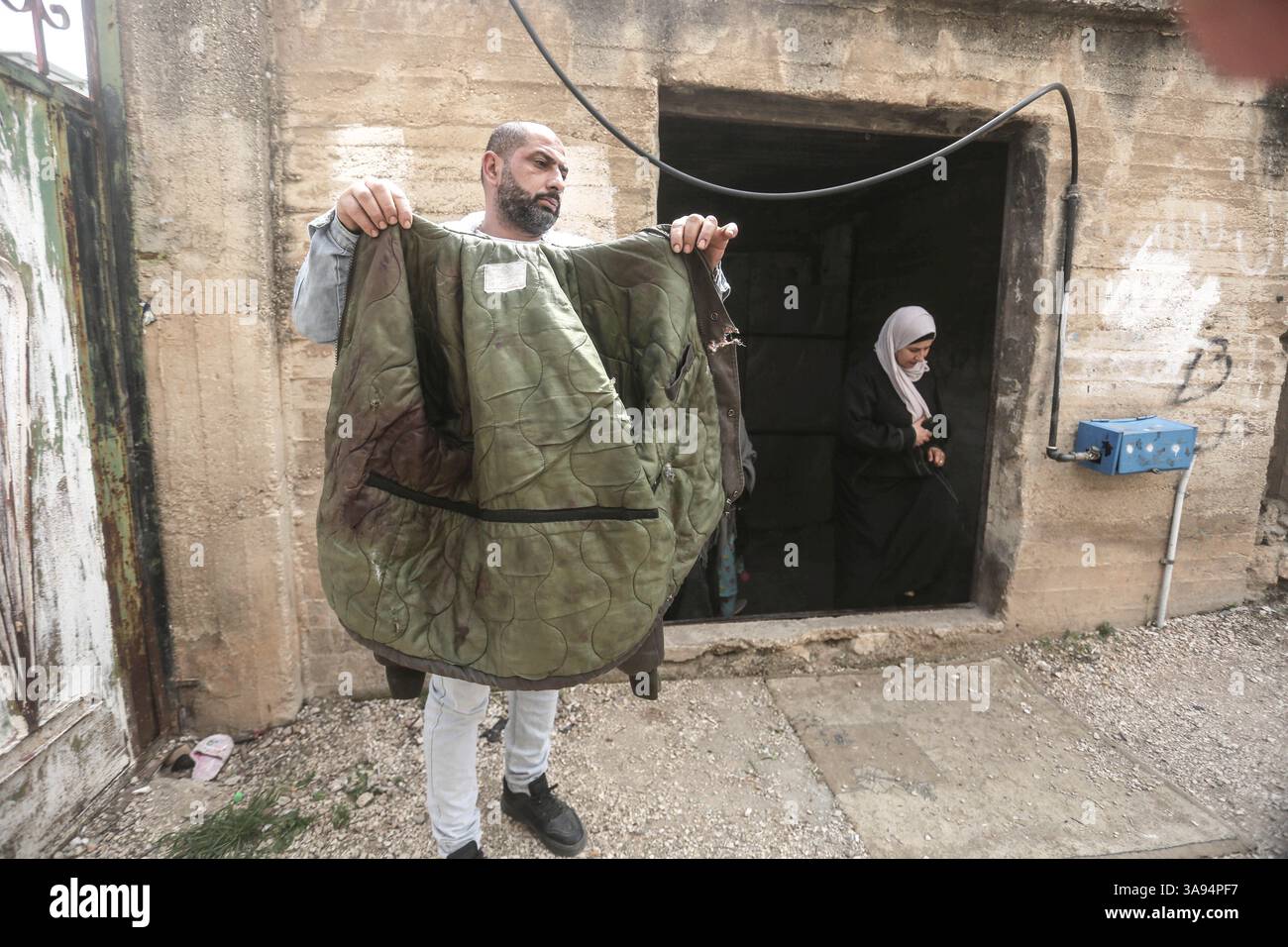 The brother of Palestinian Ahmed Bani Odeh holds his blood-stained ...