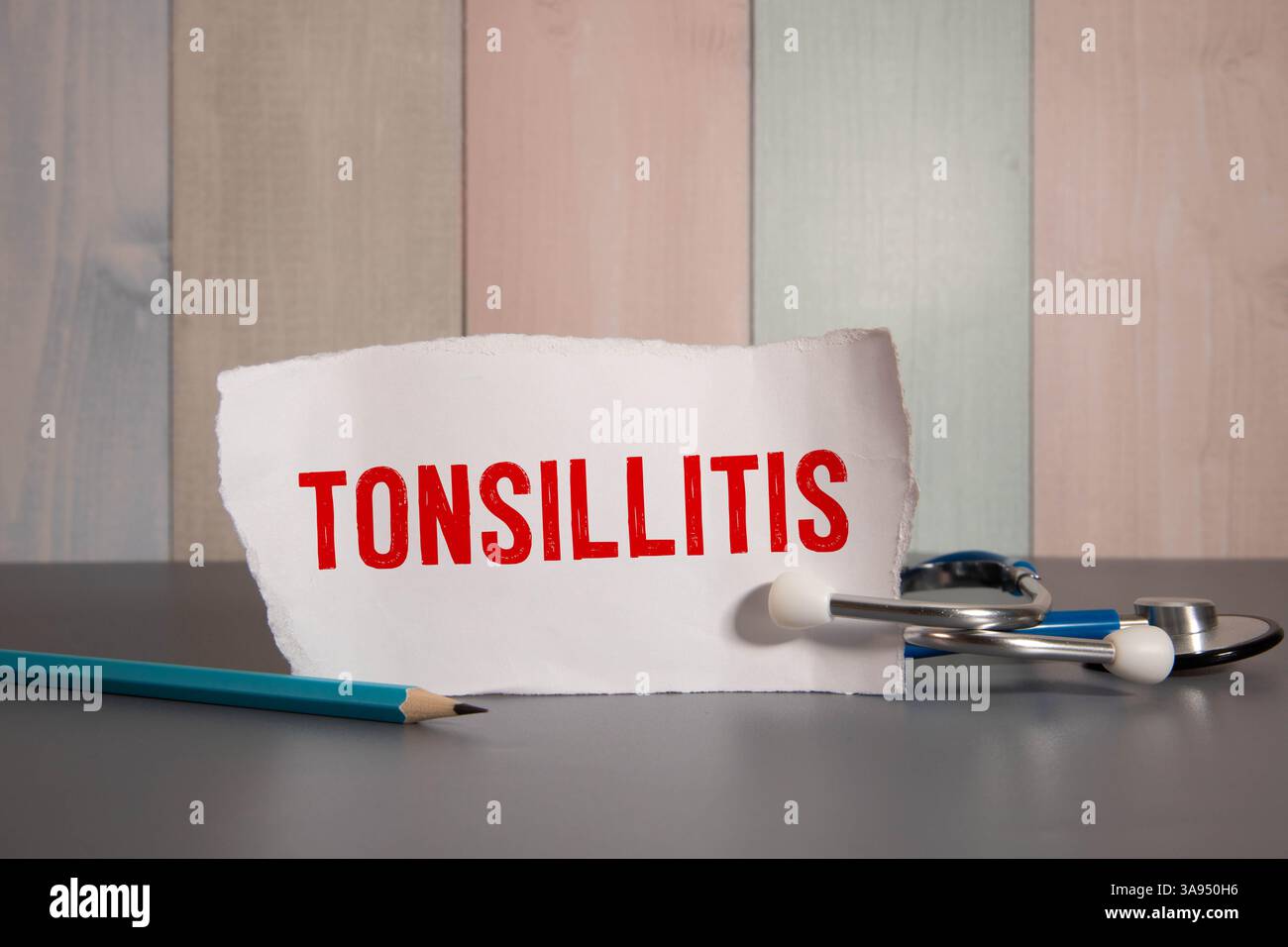 Doctor writing in notebook words TONSILLITIS on white background with ...