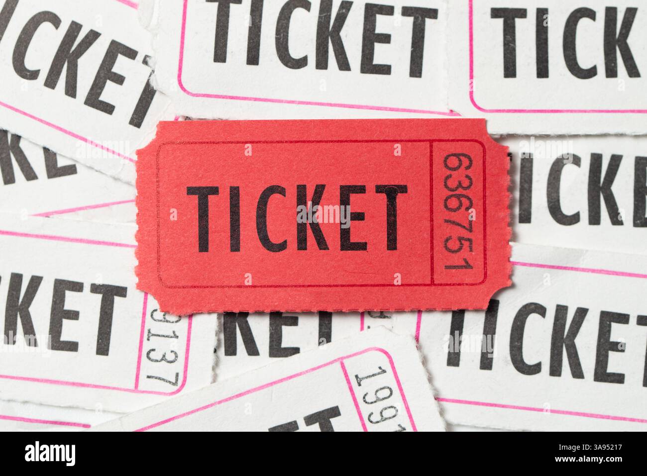 Single red vintage admission ticket on top of many white stub tickets, for movie theme design ...