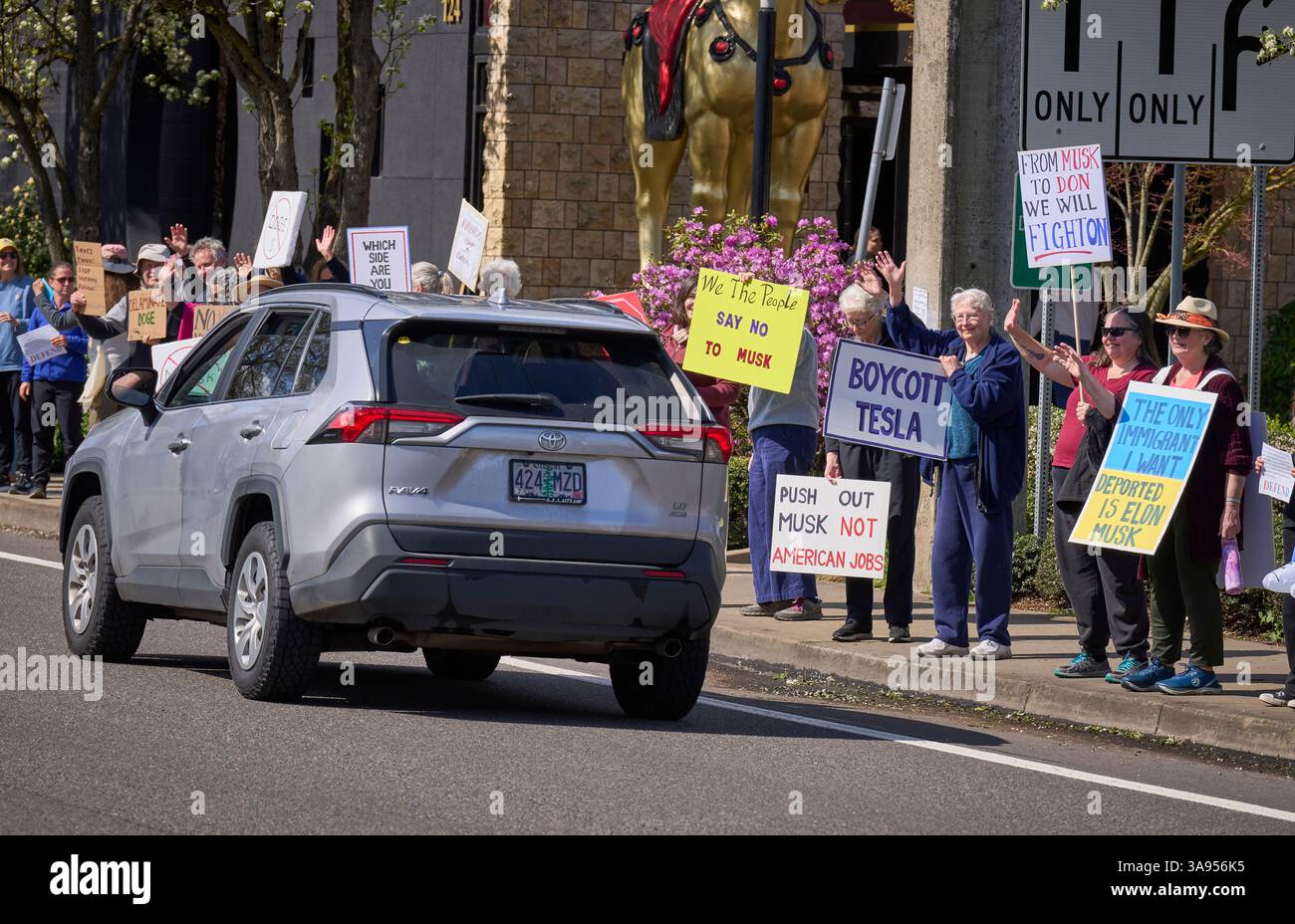Pro-democracy demonstrators call for a boycott of Tesla in Eugene ...