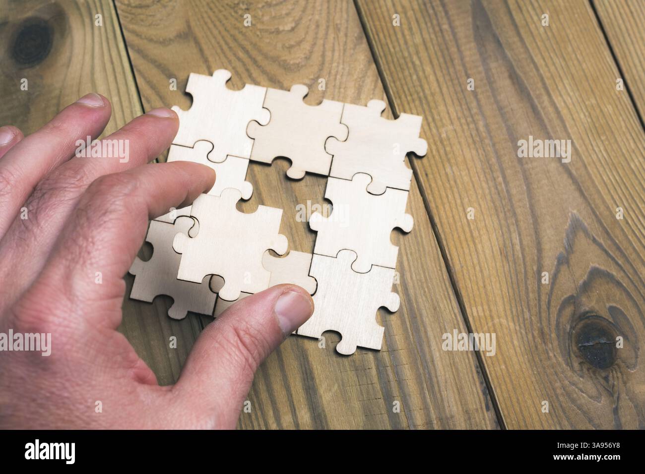 A hand is holding a puzzle piece that is missing. The puzzle piece is ...