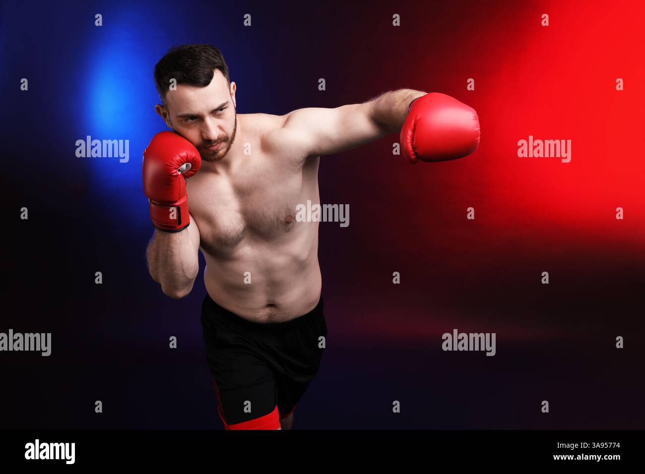 Man with boxing gloves fighting on dark background in neon lights Stock ...