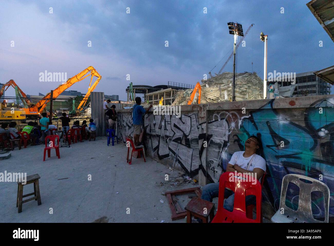Relatives of victims wait as rescuers work at the site of a collapsed ...
