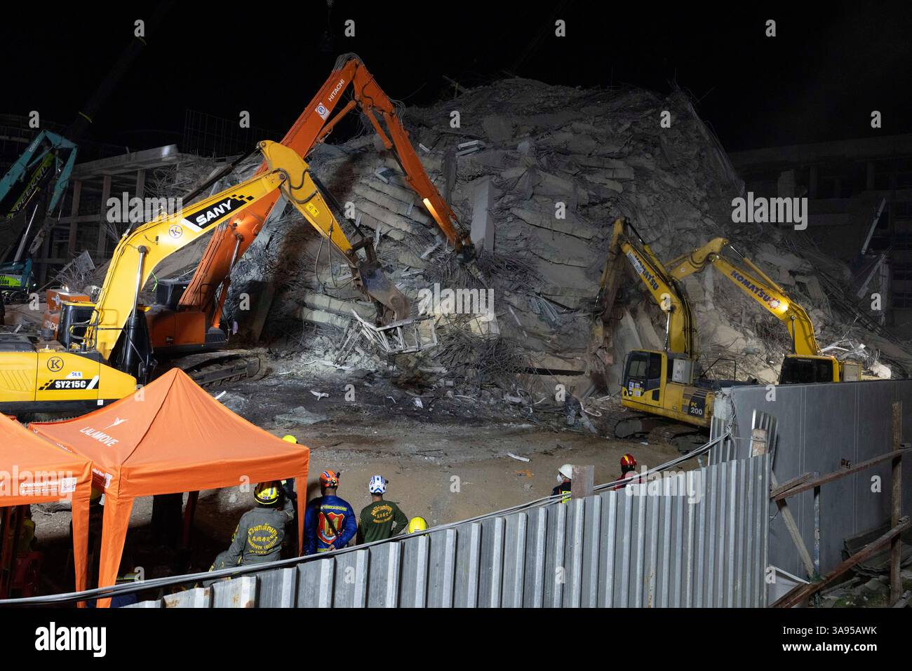 Rescuers work at the site of a collapsed under construction high-rise ...