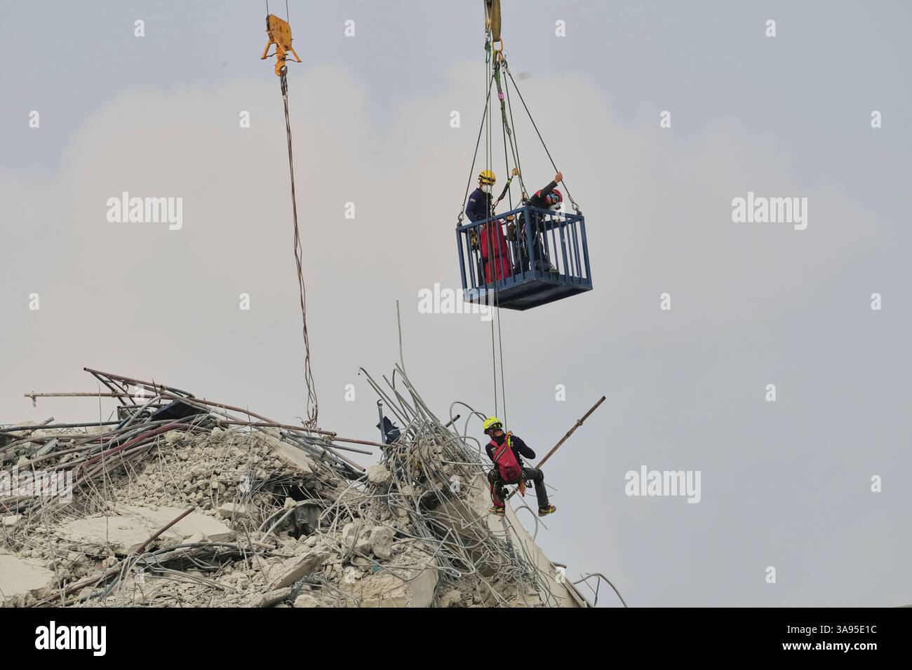 Rescuers work at the site of an under-construction high-rise building ...