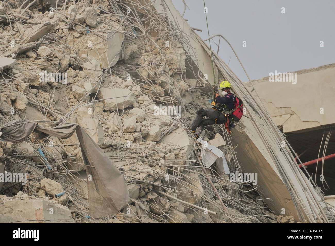 Rescuers work at the site of an under-construction high-rise building ...