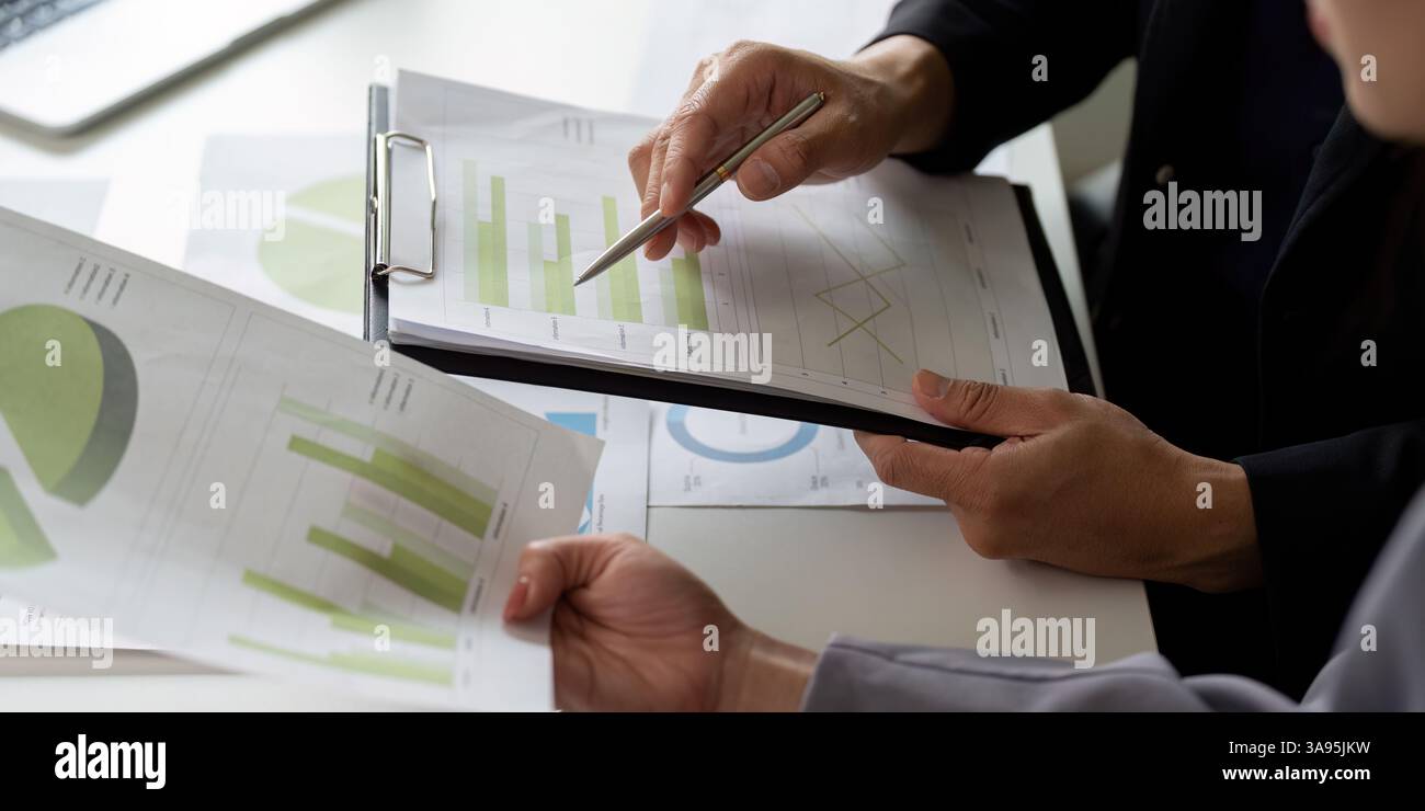 Collaboration and Data Analysis. Colleagues reviewing business reports ...