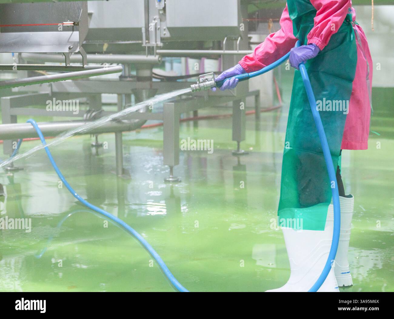 Worker cleaning flooring Factory in process line after production ...