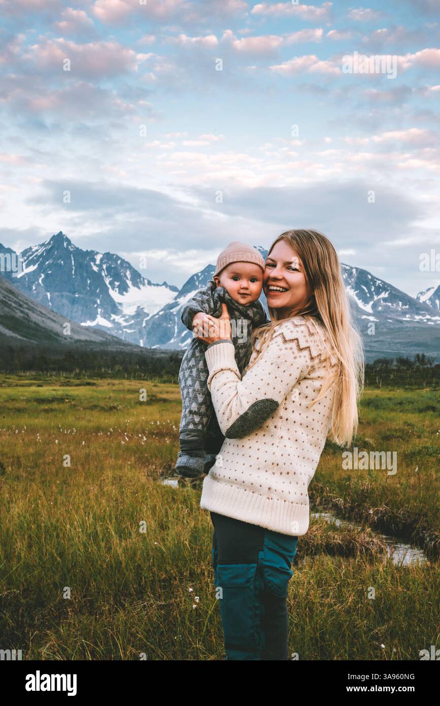 Family mother traveling with baby in Norway parent and child hiking in mountains together ...