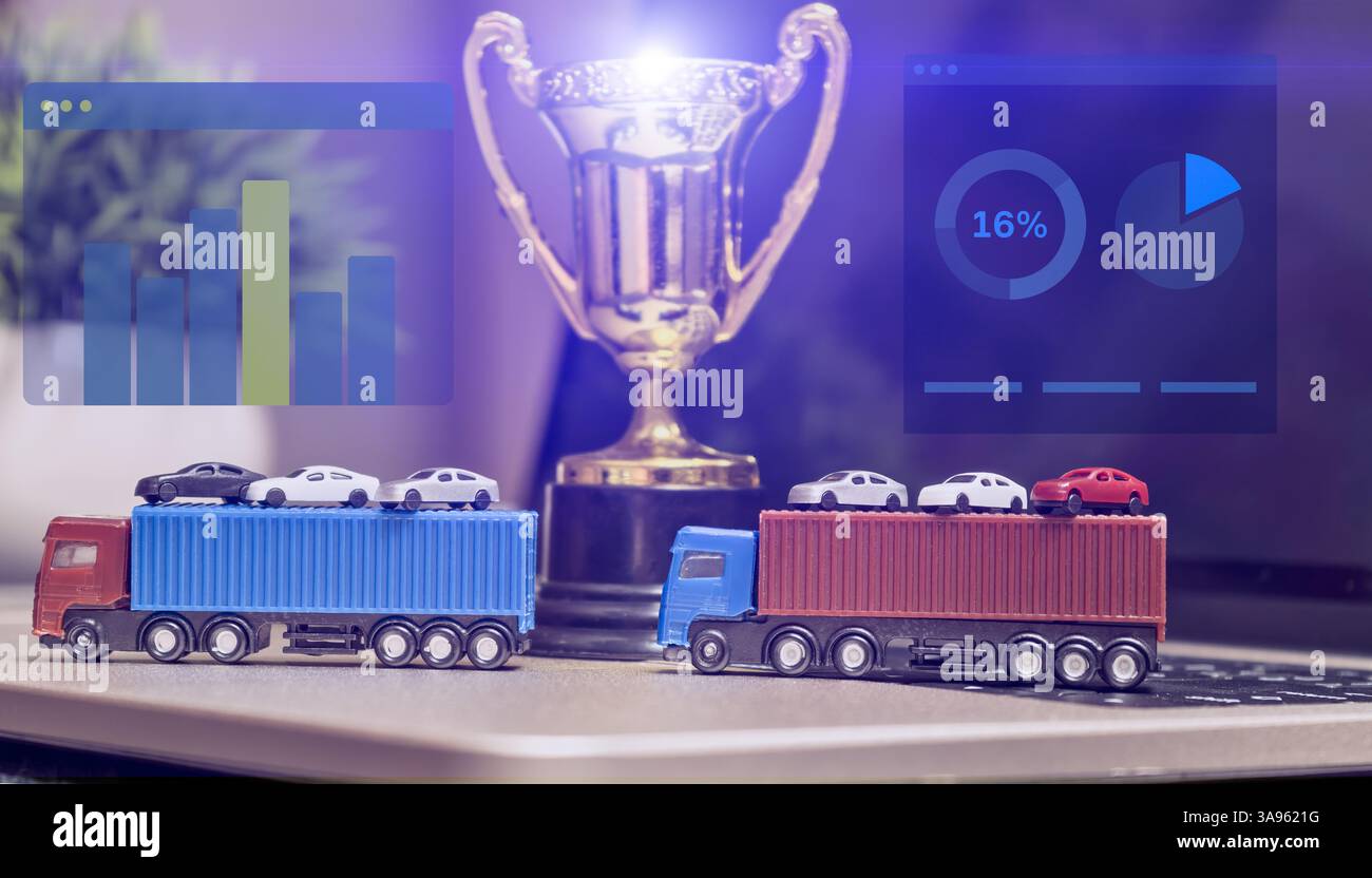 Toy cargo trucks carrying miniature cars on a laptop keyboard with a ...