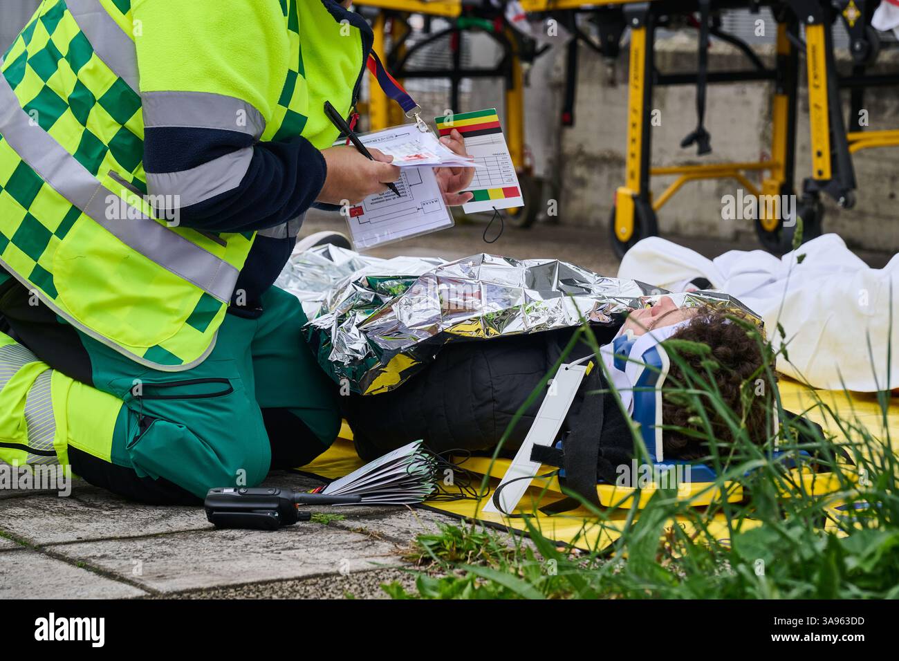 Paramedics providing emergency care to a patient covered with a thermal ...