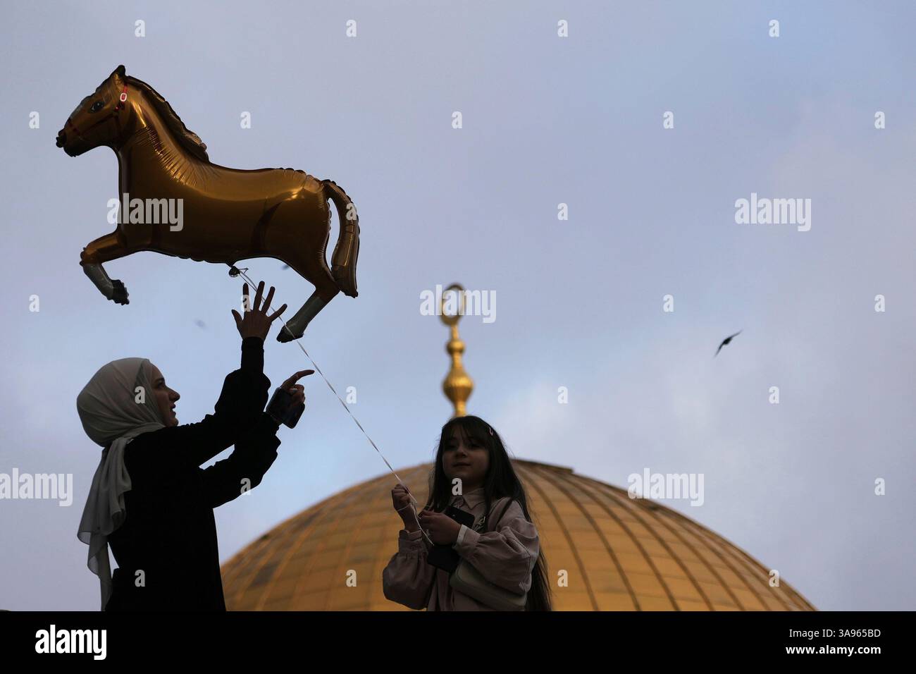 Palestinians attend Eid al-Fitr holiday celebrations by the Dome of the ...