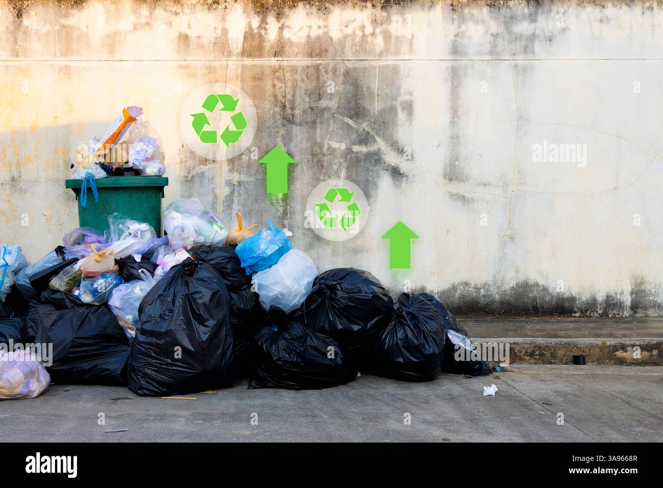 Piles of trash and overflowing bins against a dirty wall with recycling ...