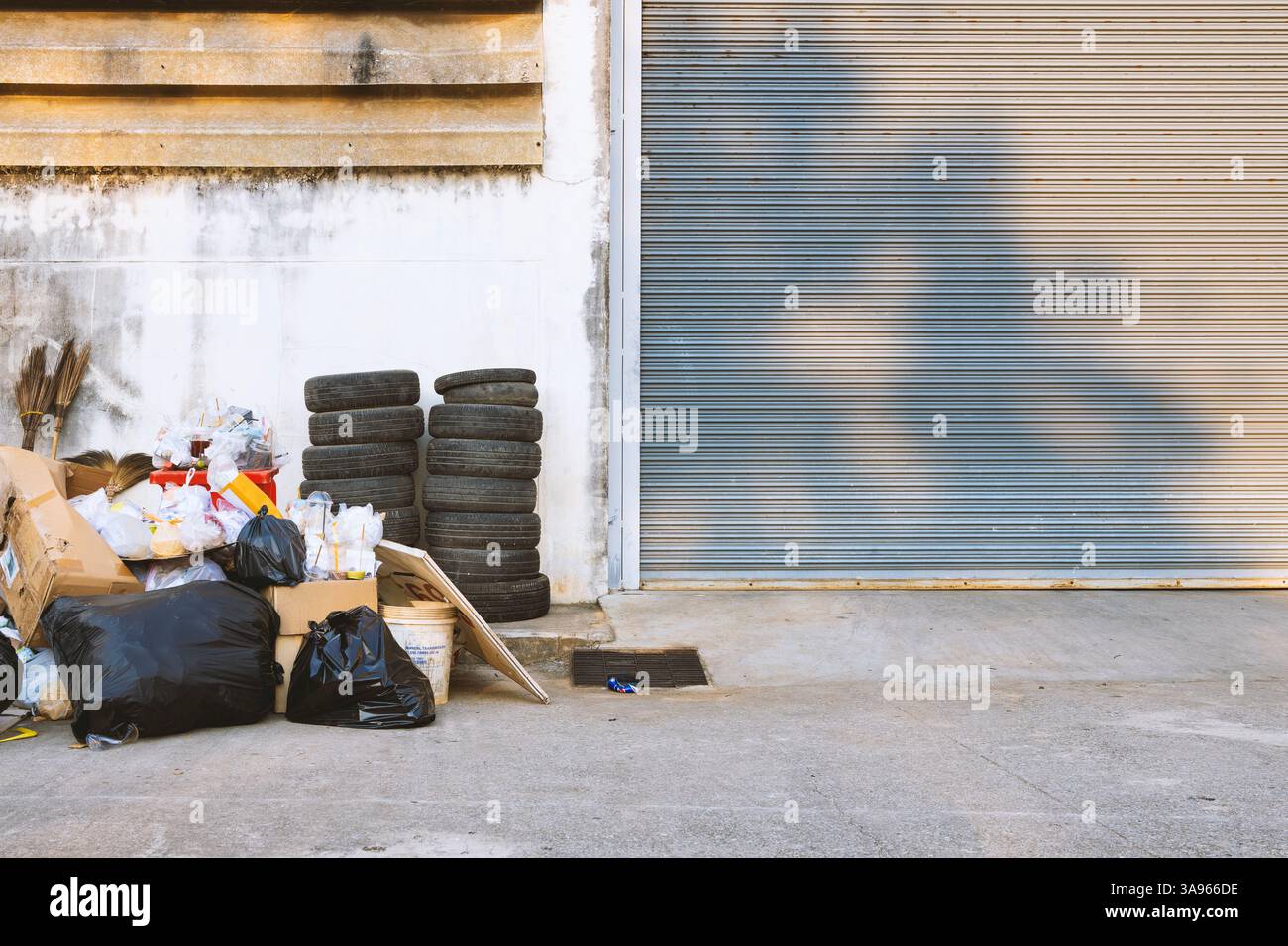 Piles of trash and overflowing bins against a dirty wall with recycling ...