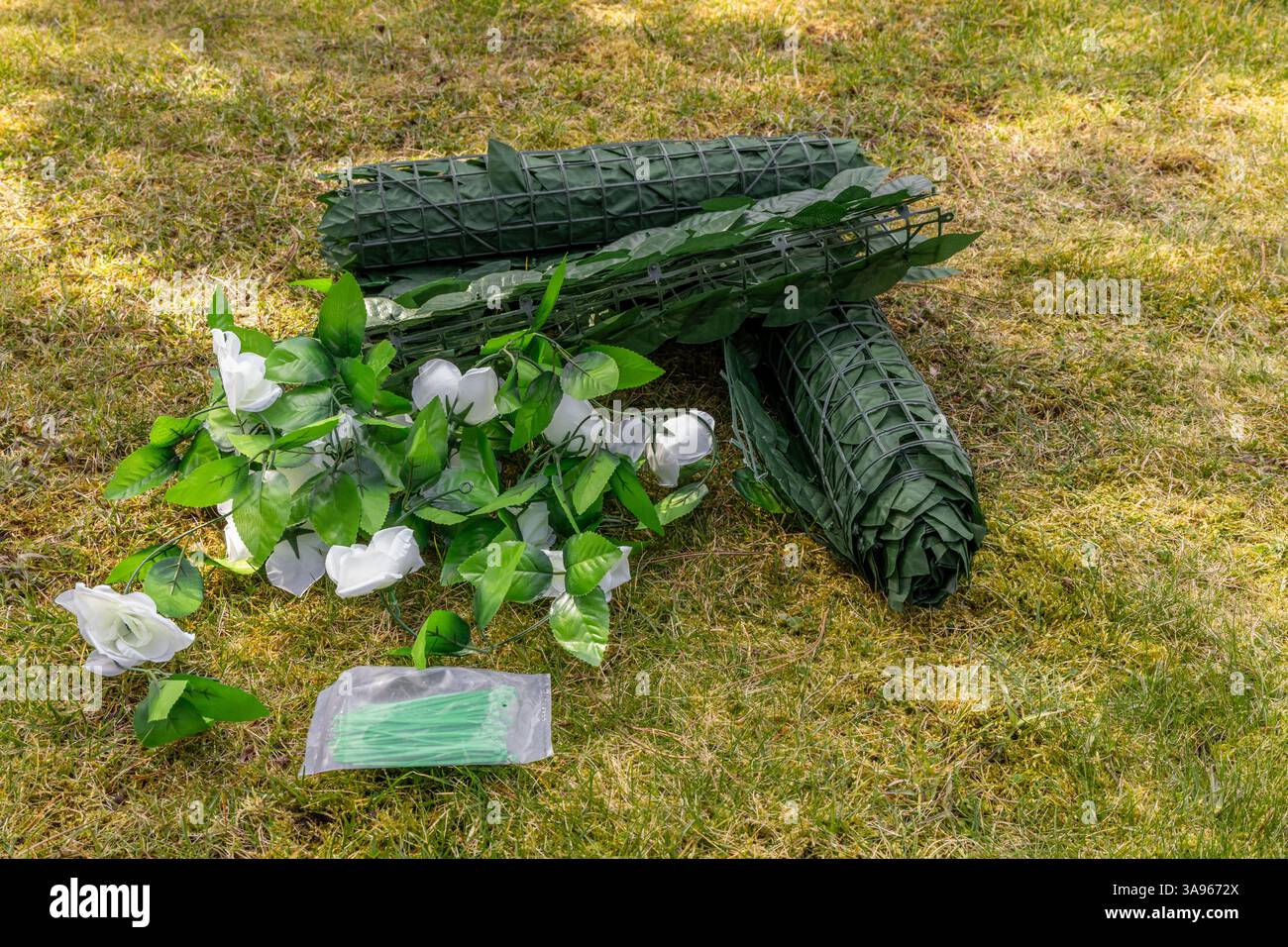 Preparing for the installation of artificial leaf netting on a fence ...