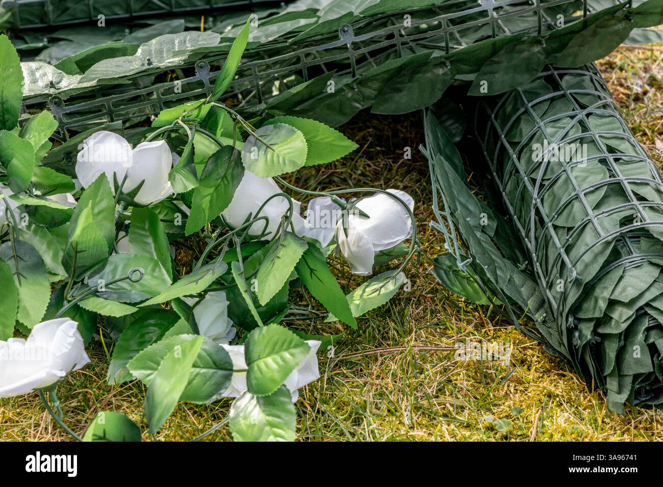 Preparing for the installation of artificial leaf netting on a fence ...