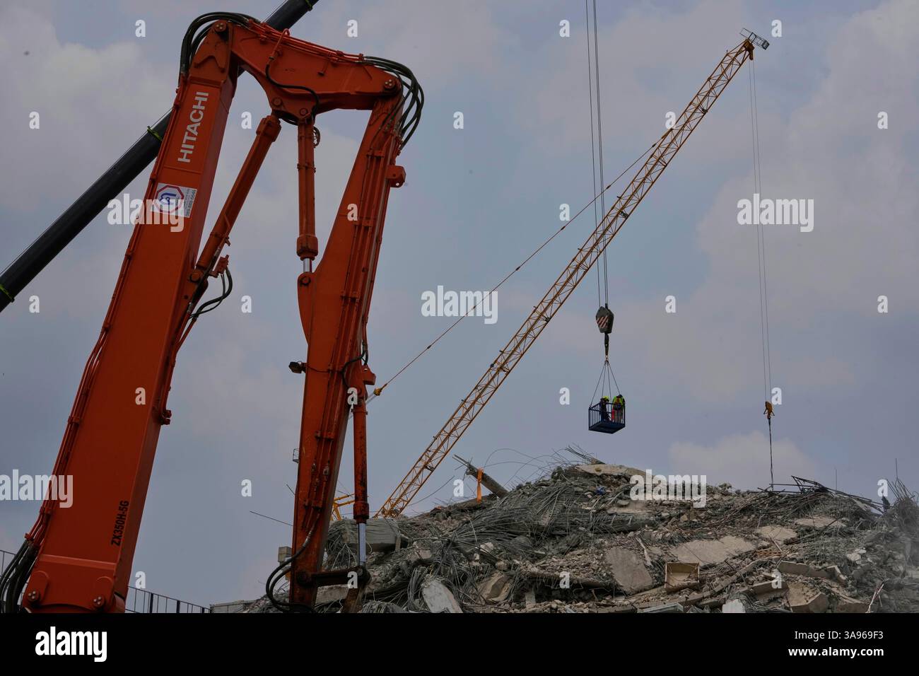 Rescuers look for the survivors at the site of an under-construction ...