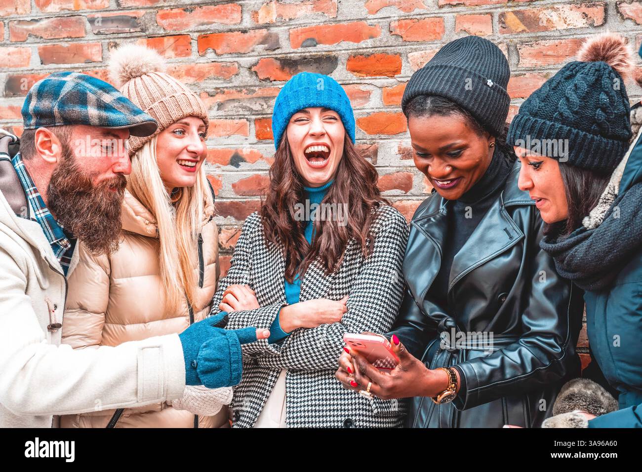 Multiethnic friends laughing and sharing moments while looking at a ...