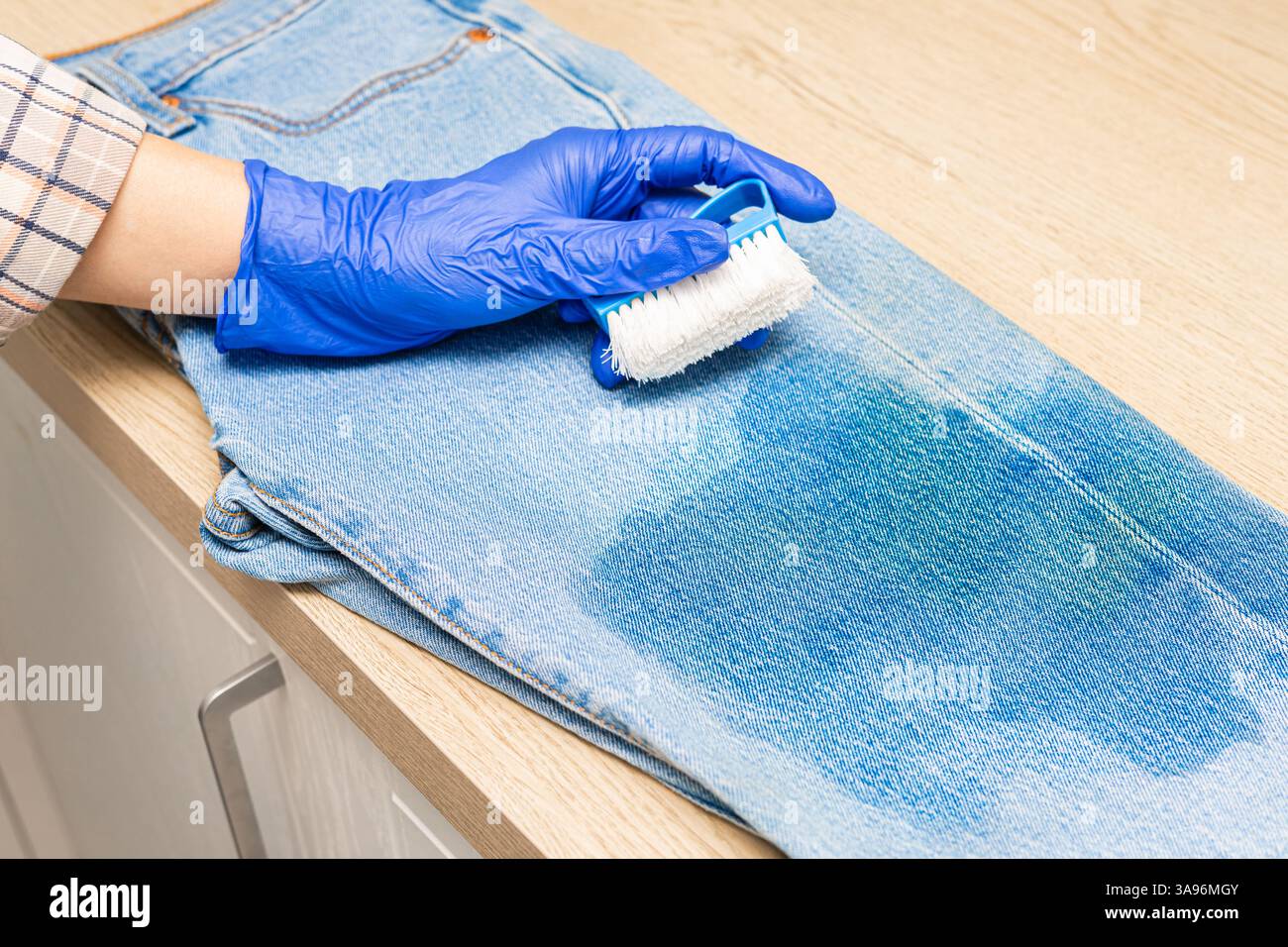 man cleaning jeans from dirt with a brush. woman removing dirty stain ...