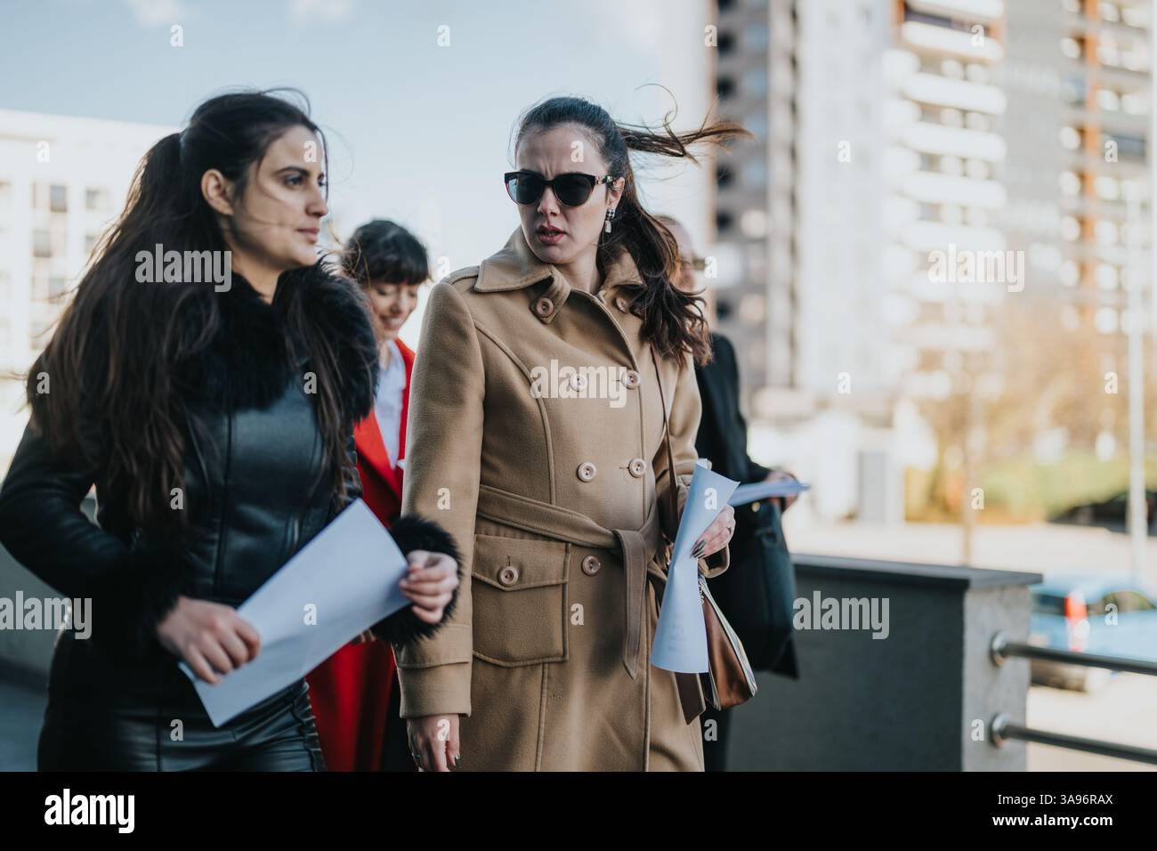 Group of professionals walking outdoors in an urban area on a windy day ...
